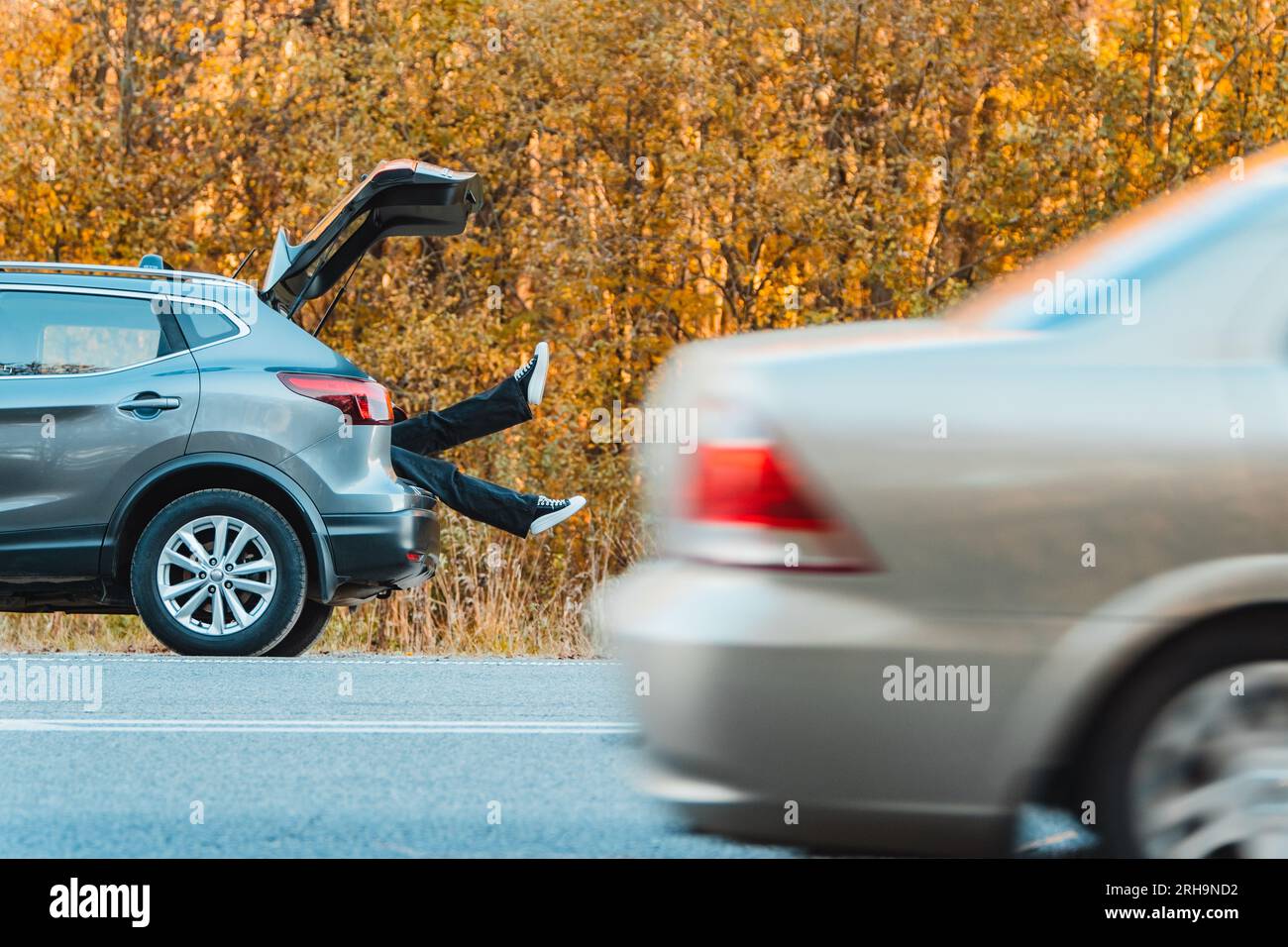 After a long road trip, woman is taking a break for some rest. legs are ...