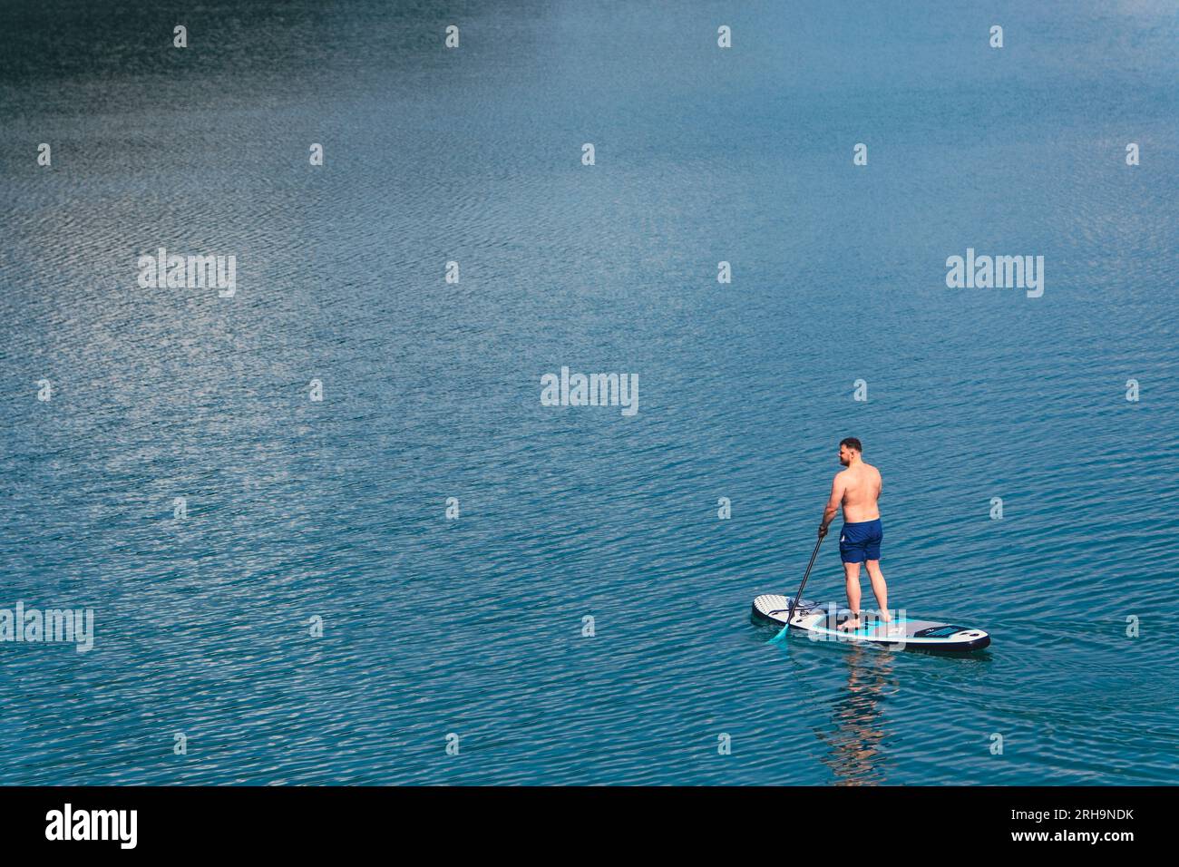 man balancing on supboard paddling Stock Photo - Alamy