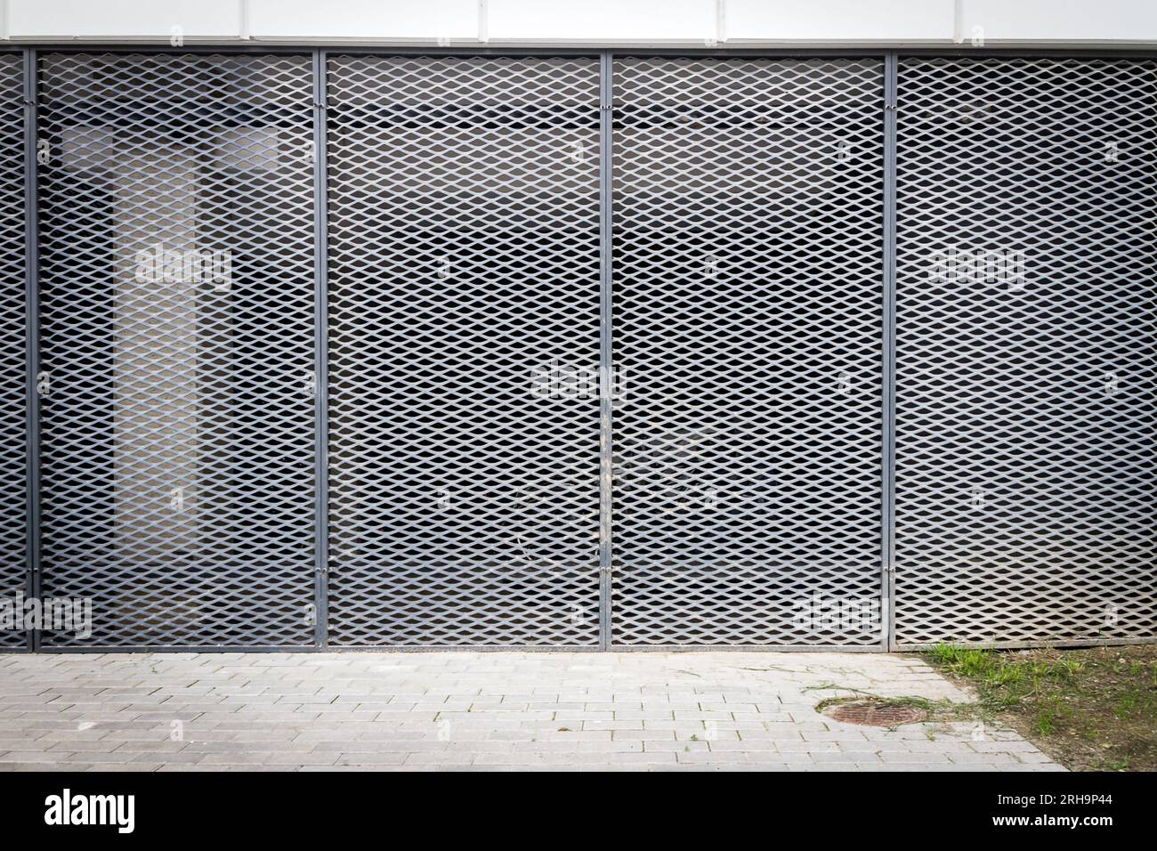 Iron grid wall and a sidewalk. Architecture detail background Stock ...