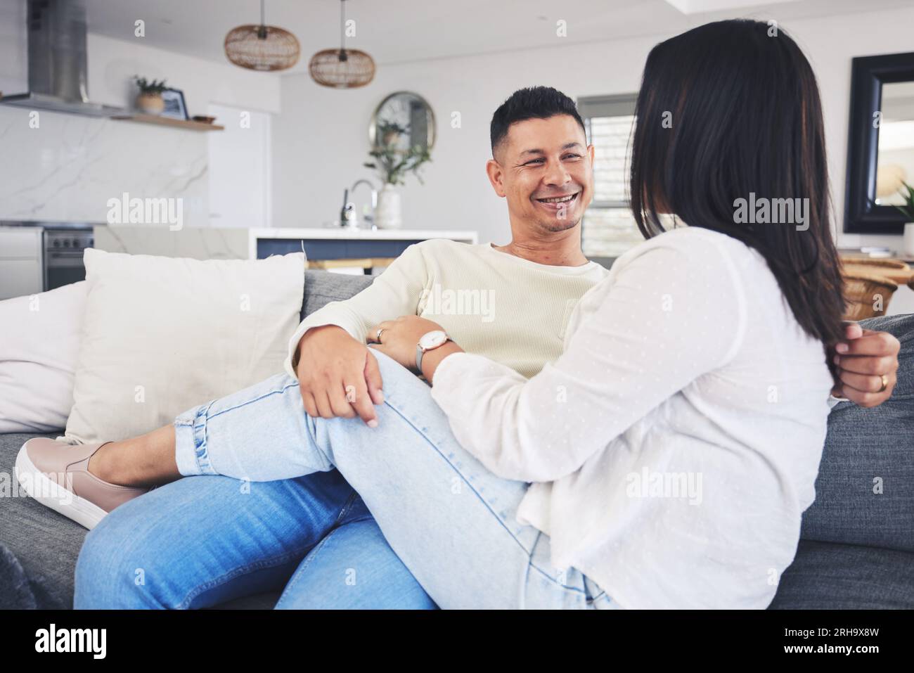 Conversation, relax and couple on a sofa in the living room talking and ...