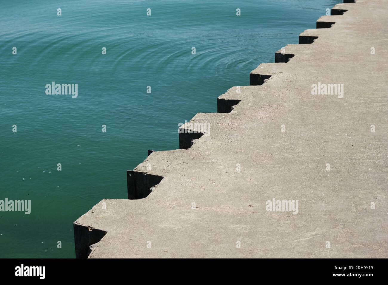 Minimalist view of a corrugated steel retaining wall creating a pier ...