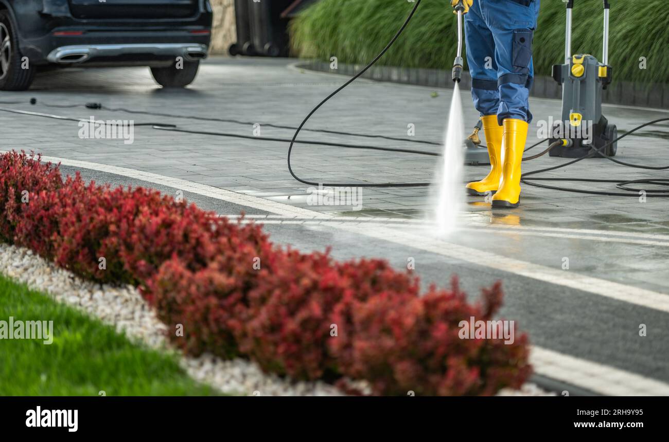 Homeowner Power Washing Residential Driveway Using Pressure Washer ...