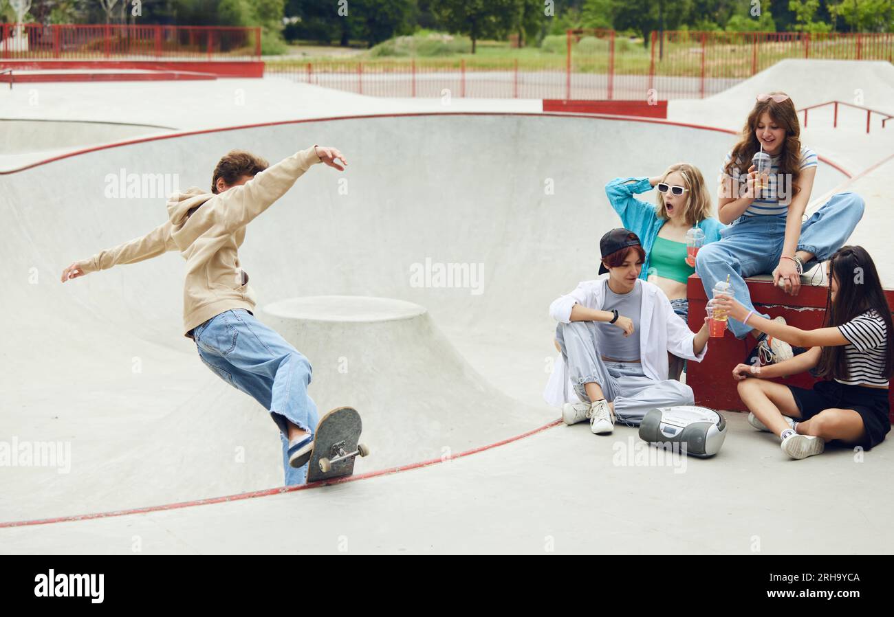Cheerful friends, teens meeting together at skateboard park, having fun ...
