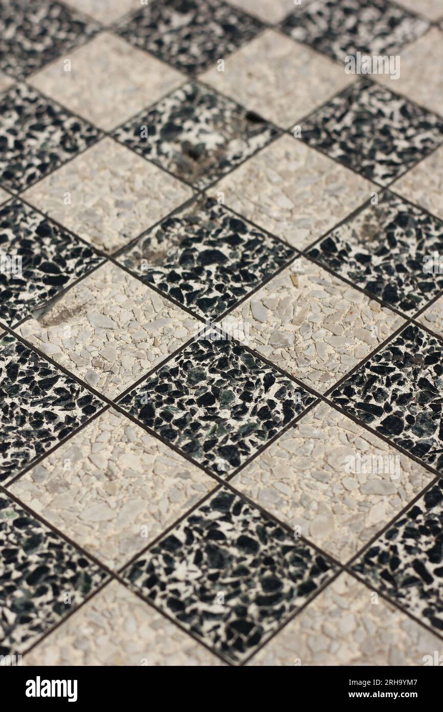 Repeating pattern of square tiles with perpendicular lines and gravel ...