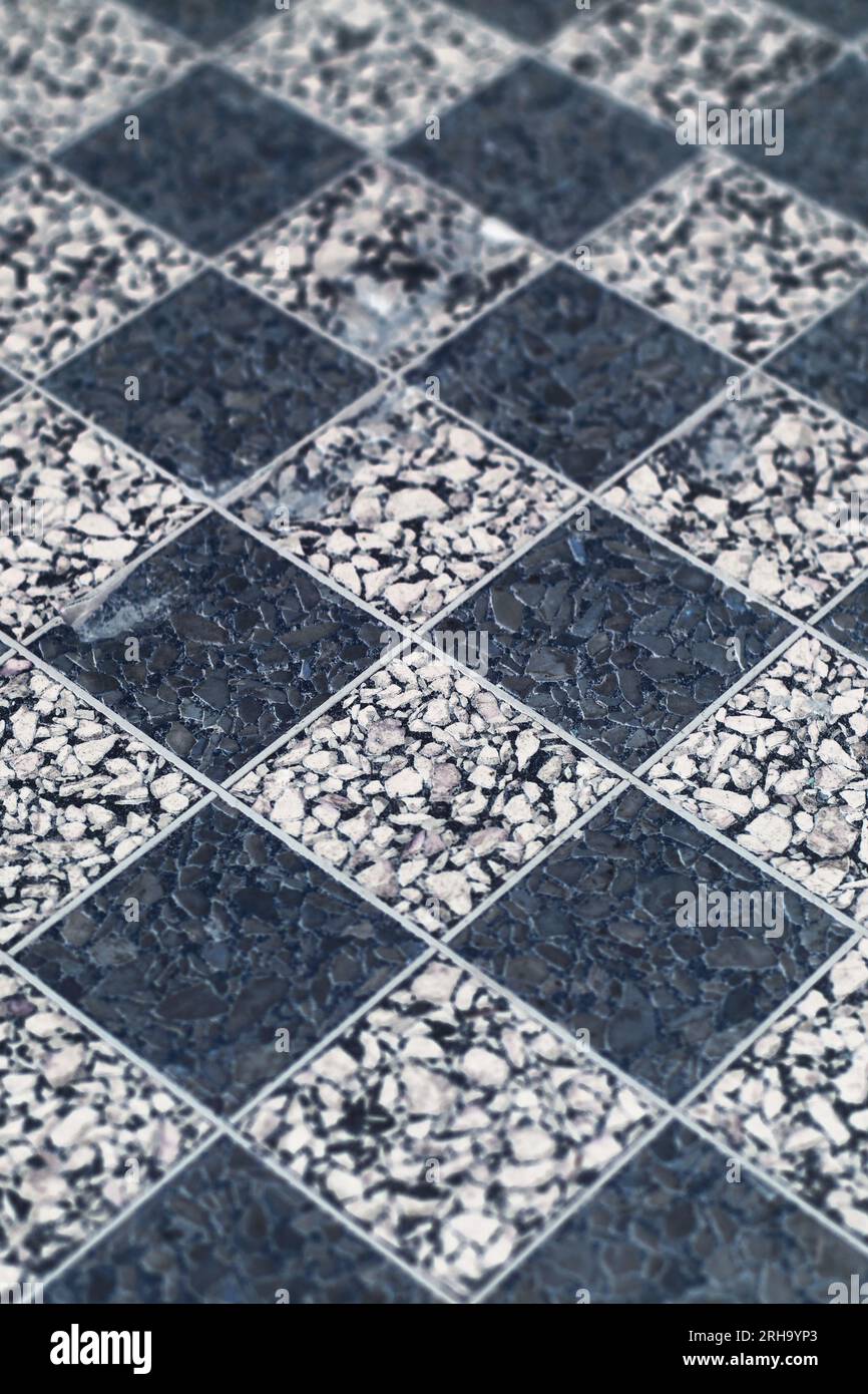 Repeating patternof square tiles with perpendicular lines and gravel ...