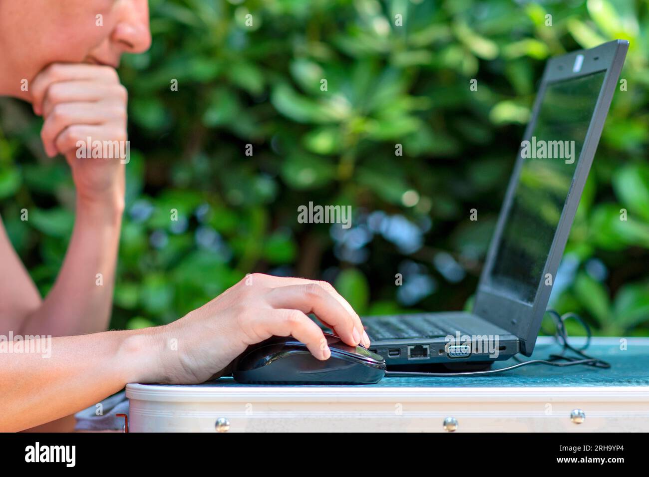 Woman working online using laptop while sitting on the camping table in ...