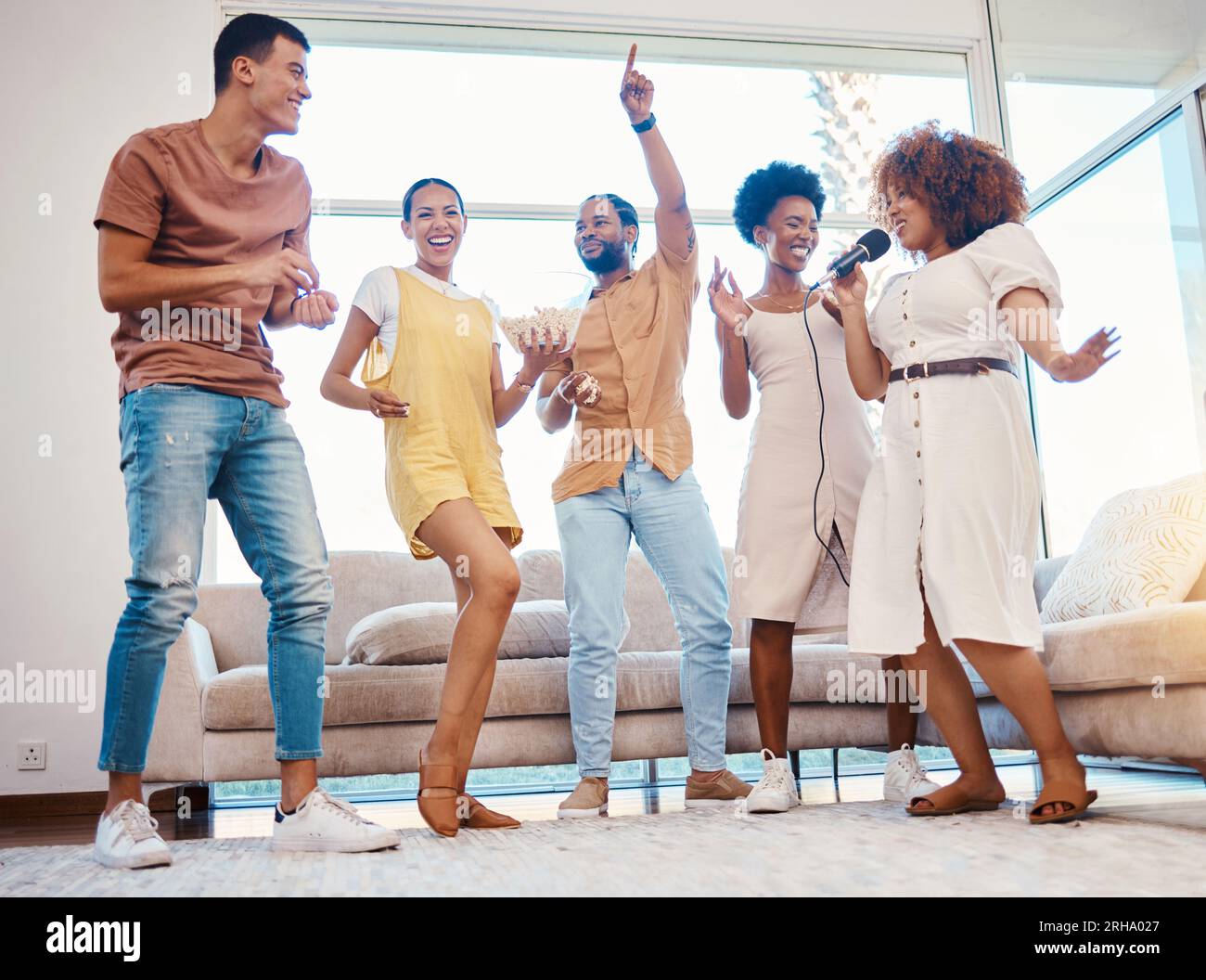 Singing, entertainment and friends dancing in living room with a ...