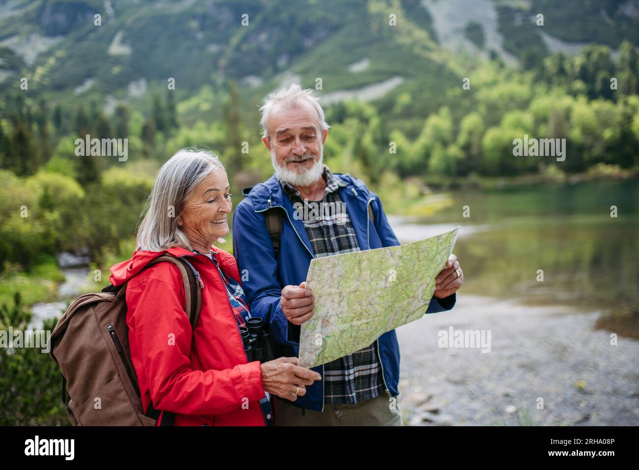 Senior tourists with backpacks reading map, preparing for hike Stock ...
