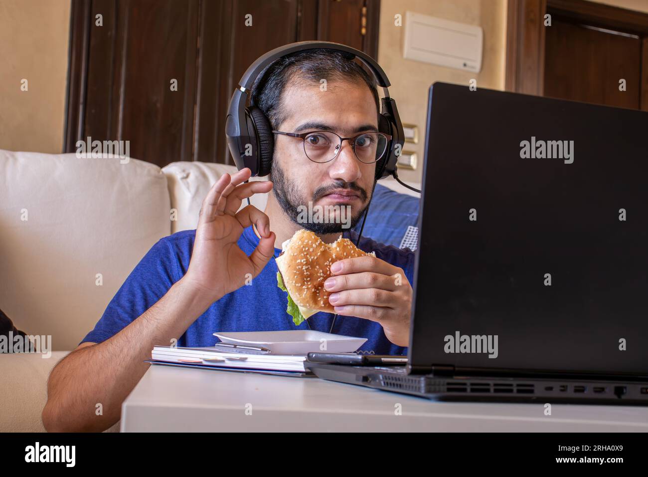 Young arabic man eating while working and at home Stock Photo - Alamy