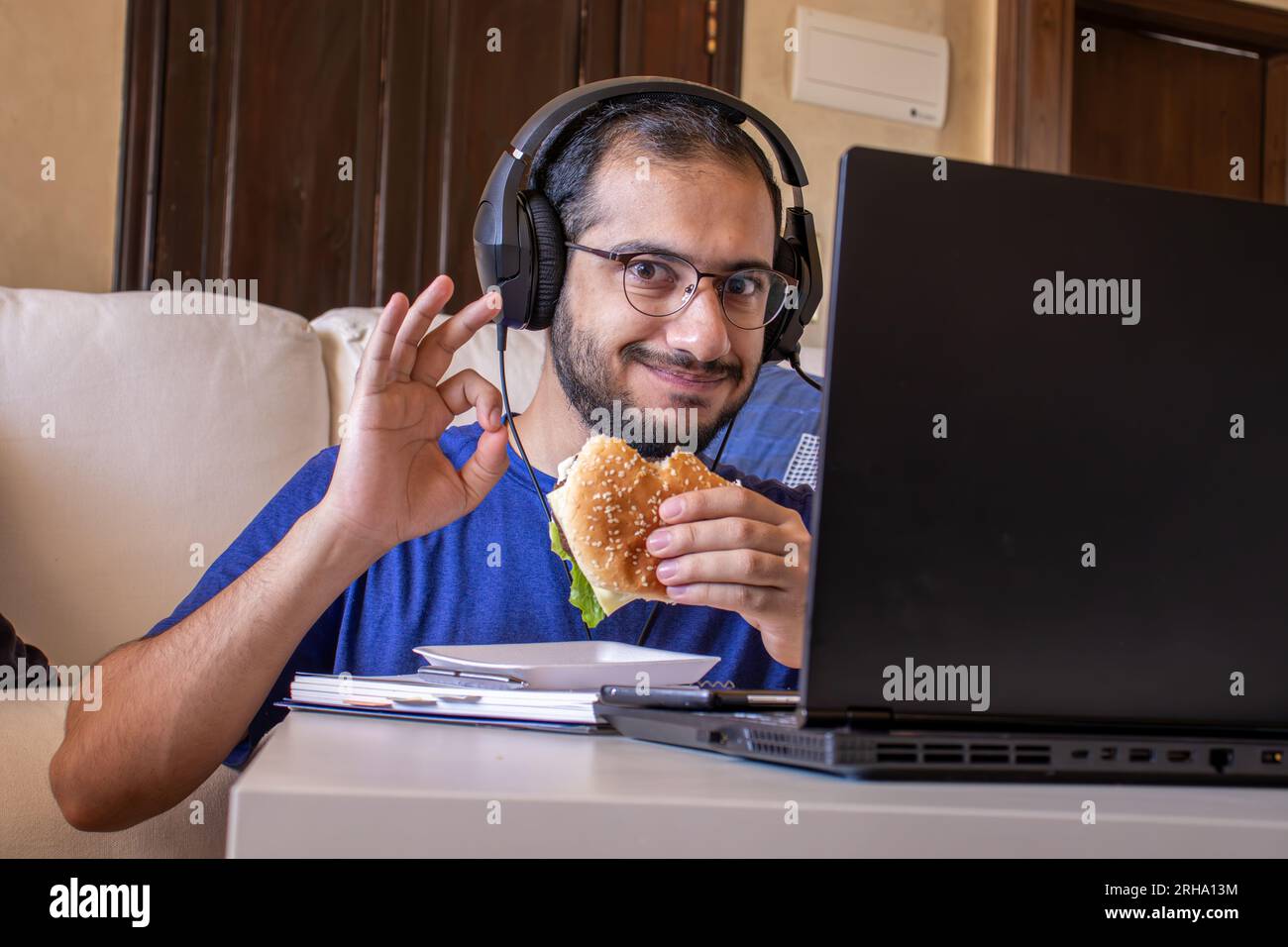 Young arabic man eating while working and at home Stock Photo - Alamy