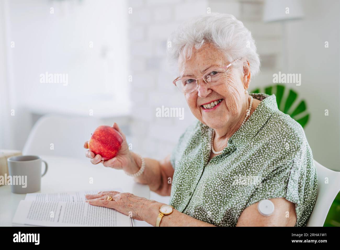 Diabetic senior patient using continuous glucose monitor to check blood ...