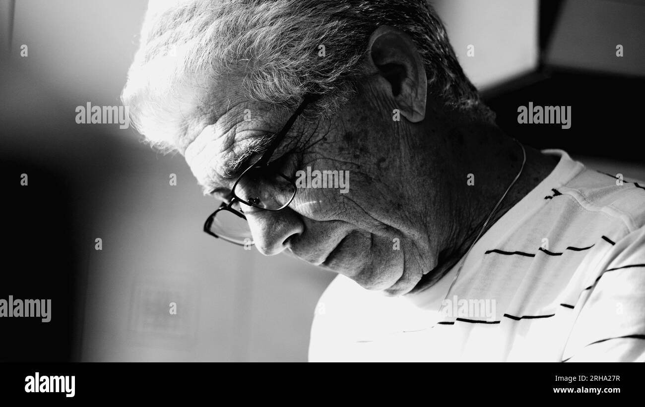 Mature man in emotional turmoil, eyes shut and in despair, monochrome ...