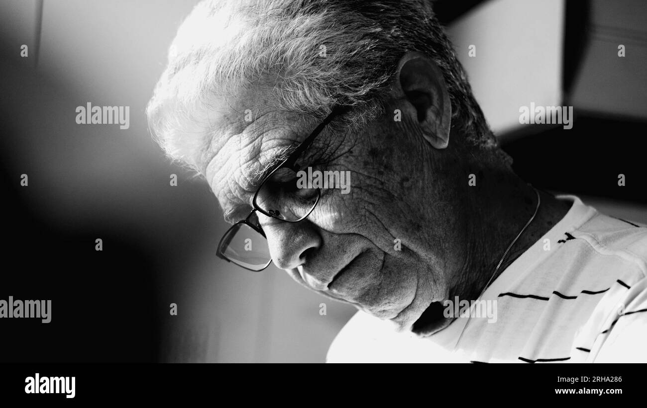Mature man in emotional turmoil, eyes shut and in despair, monochrome ...