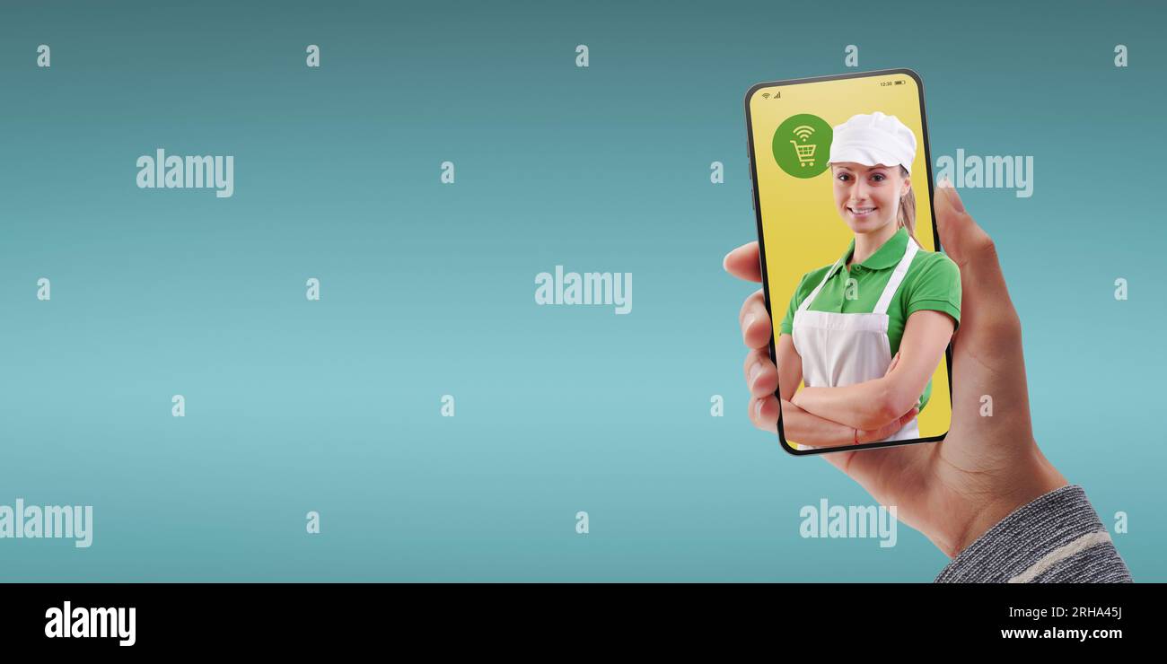Customer holding a smartphone and shop assistant: online grocery ...