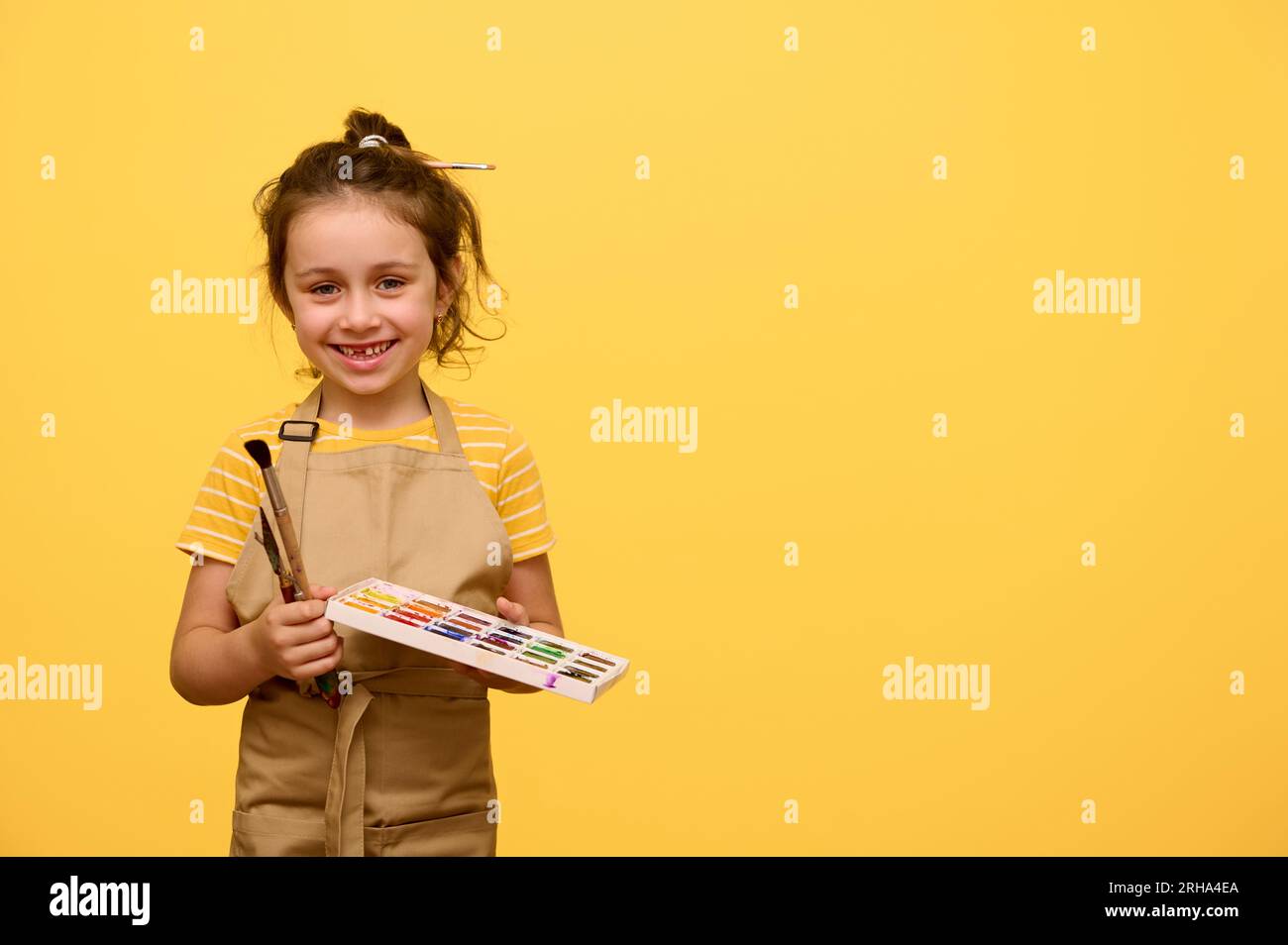 Beautiful kid girl with paint brush and watercolour palette, inspired ...