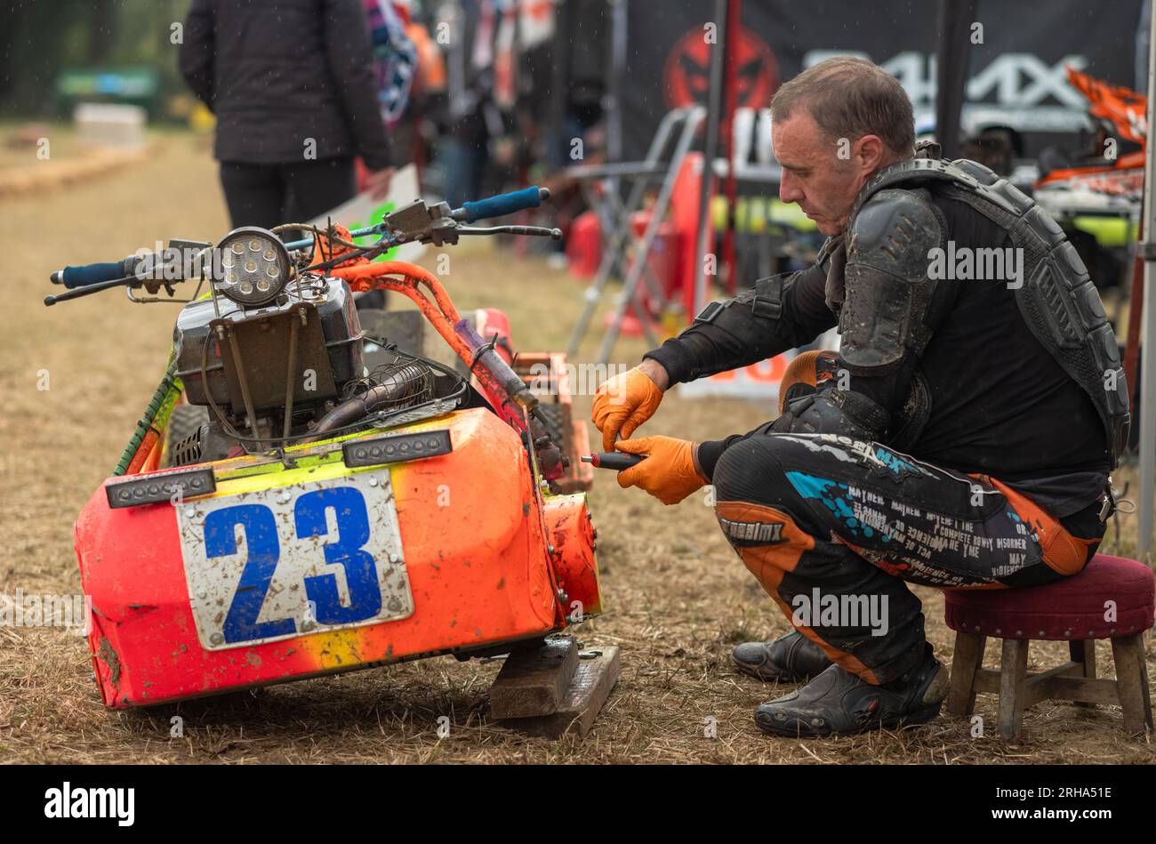 A racing lawn mower driver from "The Knight Riders" team repairs his ...