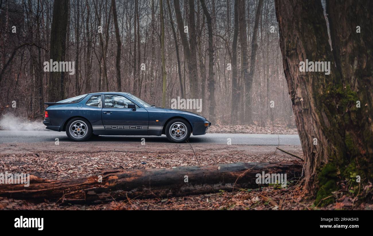 dark blue Porsche 944 in autumn forest. Side profile view of 1980s ...