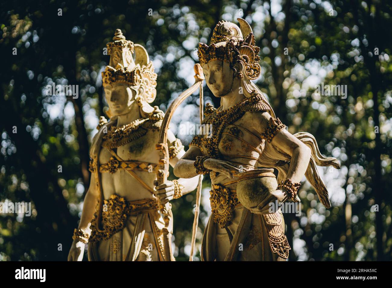 Close up shot of golden balinese statues with green nature background ...