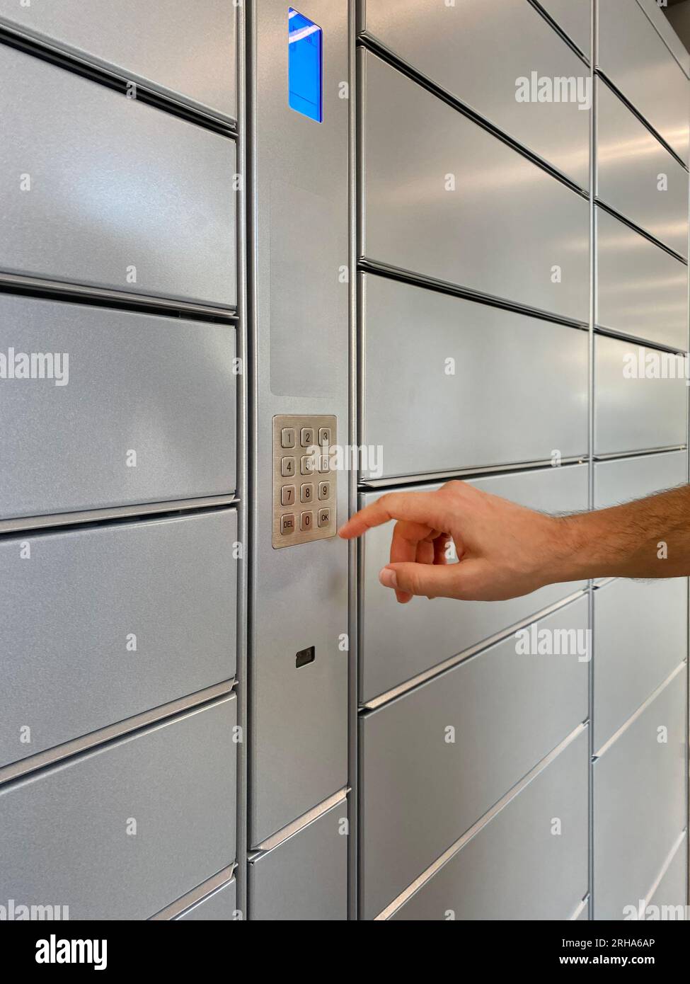 Man presses code to open cell with parcel in automatic post terminal ...