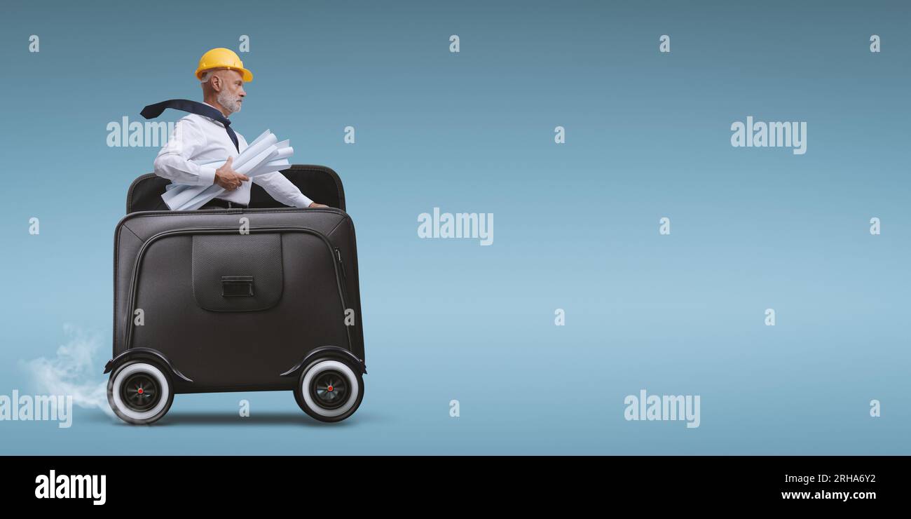 Professional architect riding a briefcase with wheels and reaching a ...