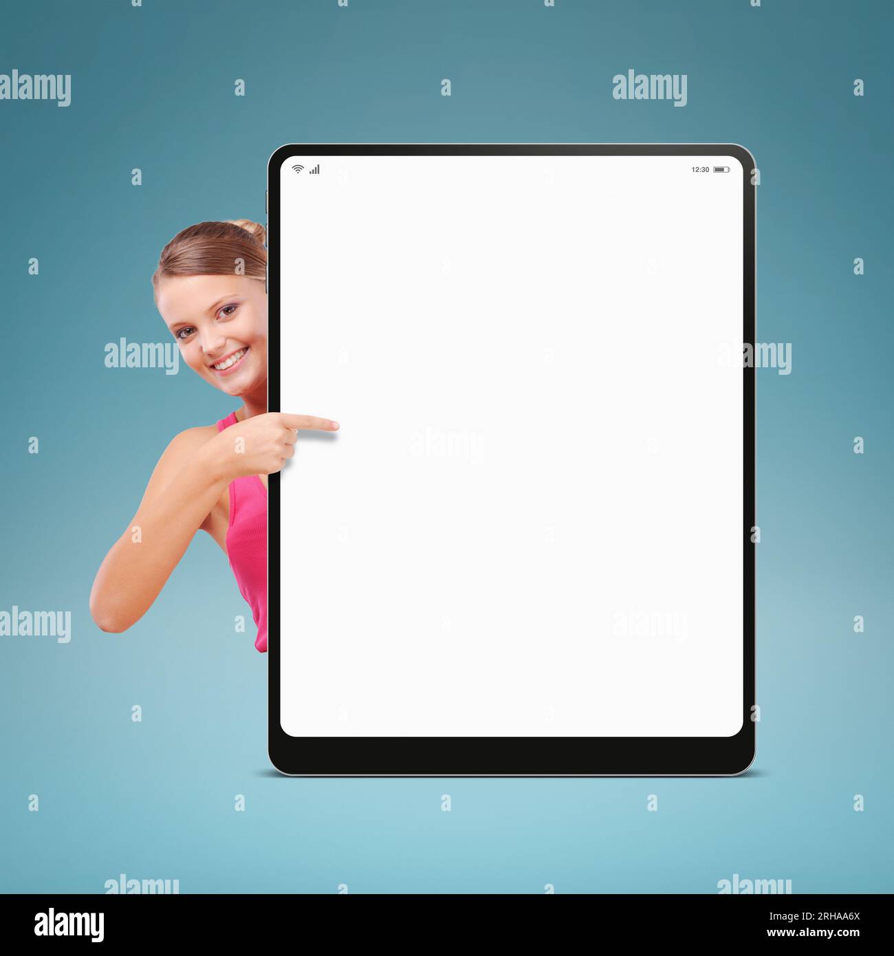Happy young woman showing a blank digital tablet and pointing at the ...