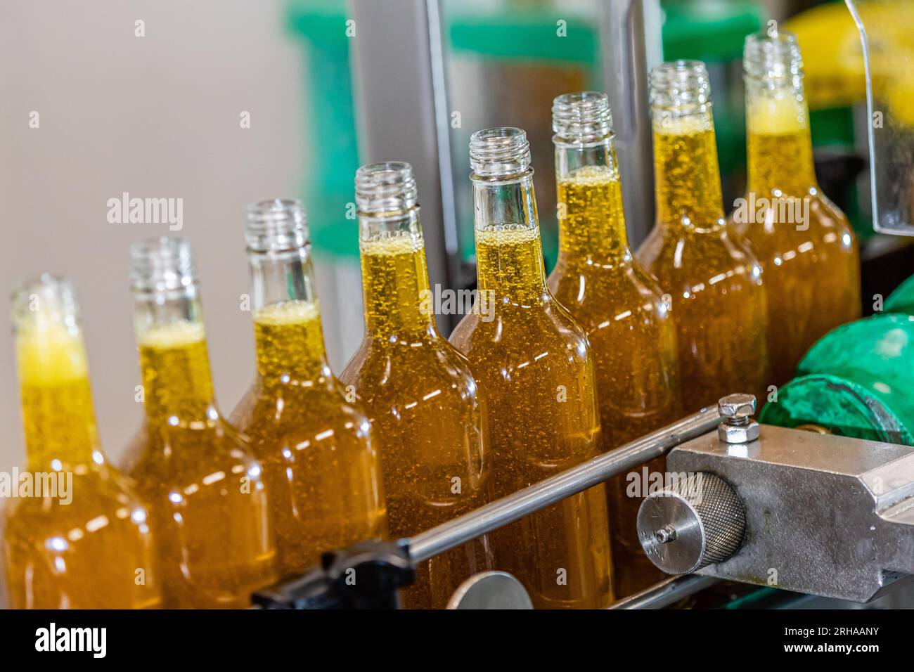Glass bottles being filled on production line at factory in the UK ...