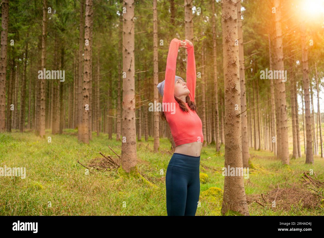 fit, sporty woman doing stretching exercises outside in the forest ...