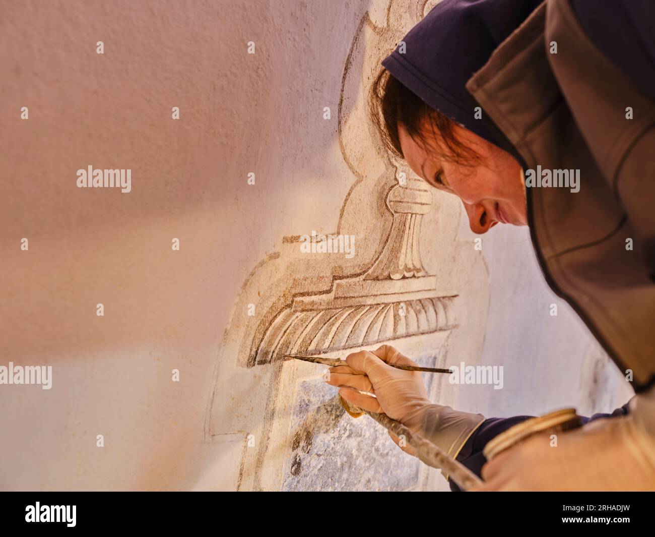 female artist doing old painting restoration. wall painting historical ...