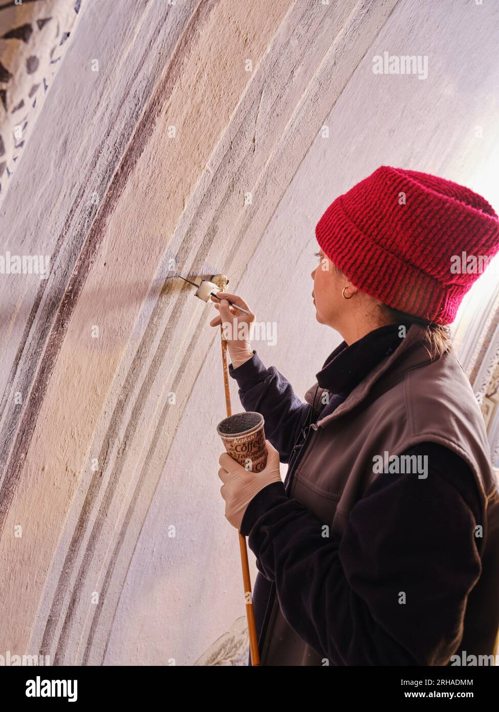female artist doing old painting restoration. wall painting historical ...