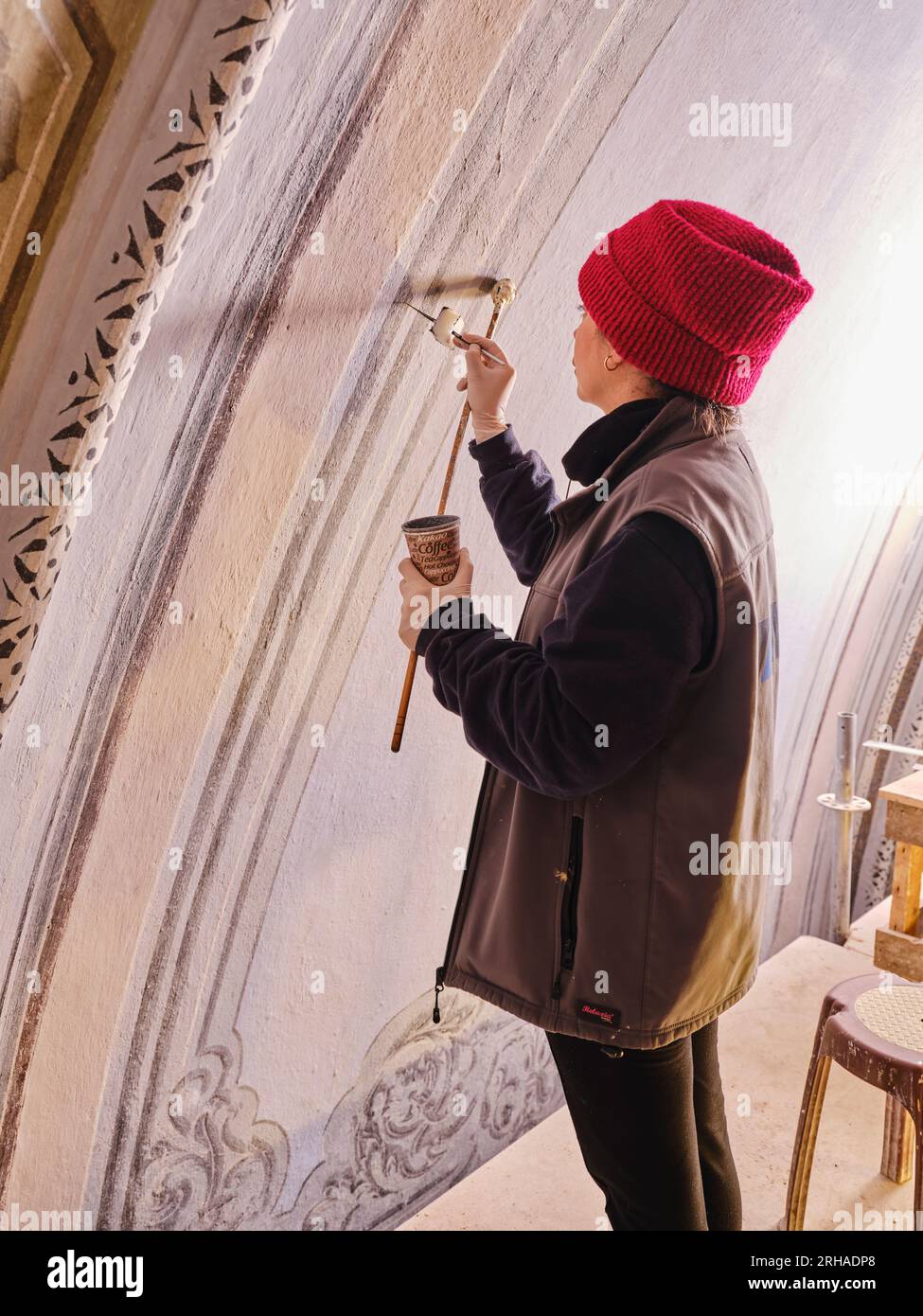 female artist doing old painting restoration. wall painting historical ...
