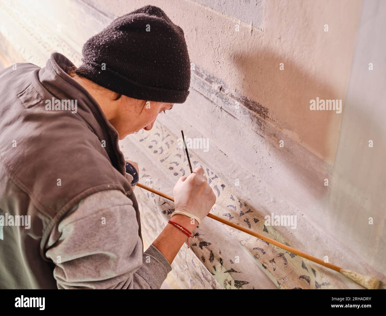 female artist doing old painting restoration. wall painting historical ...