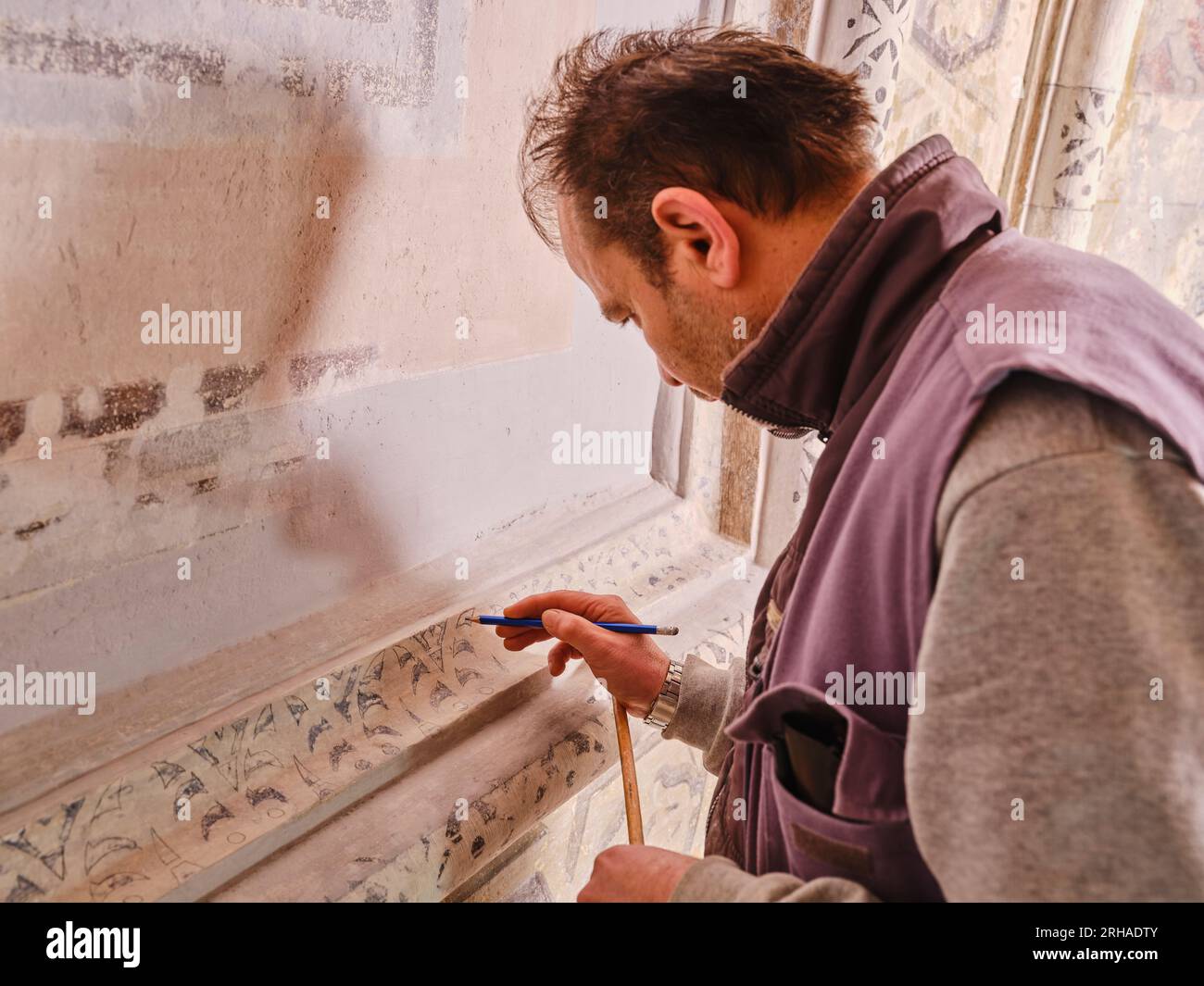 female artist doing old painting restoration. wall painting historical ...