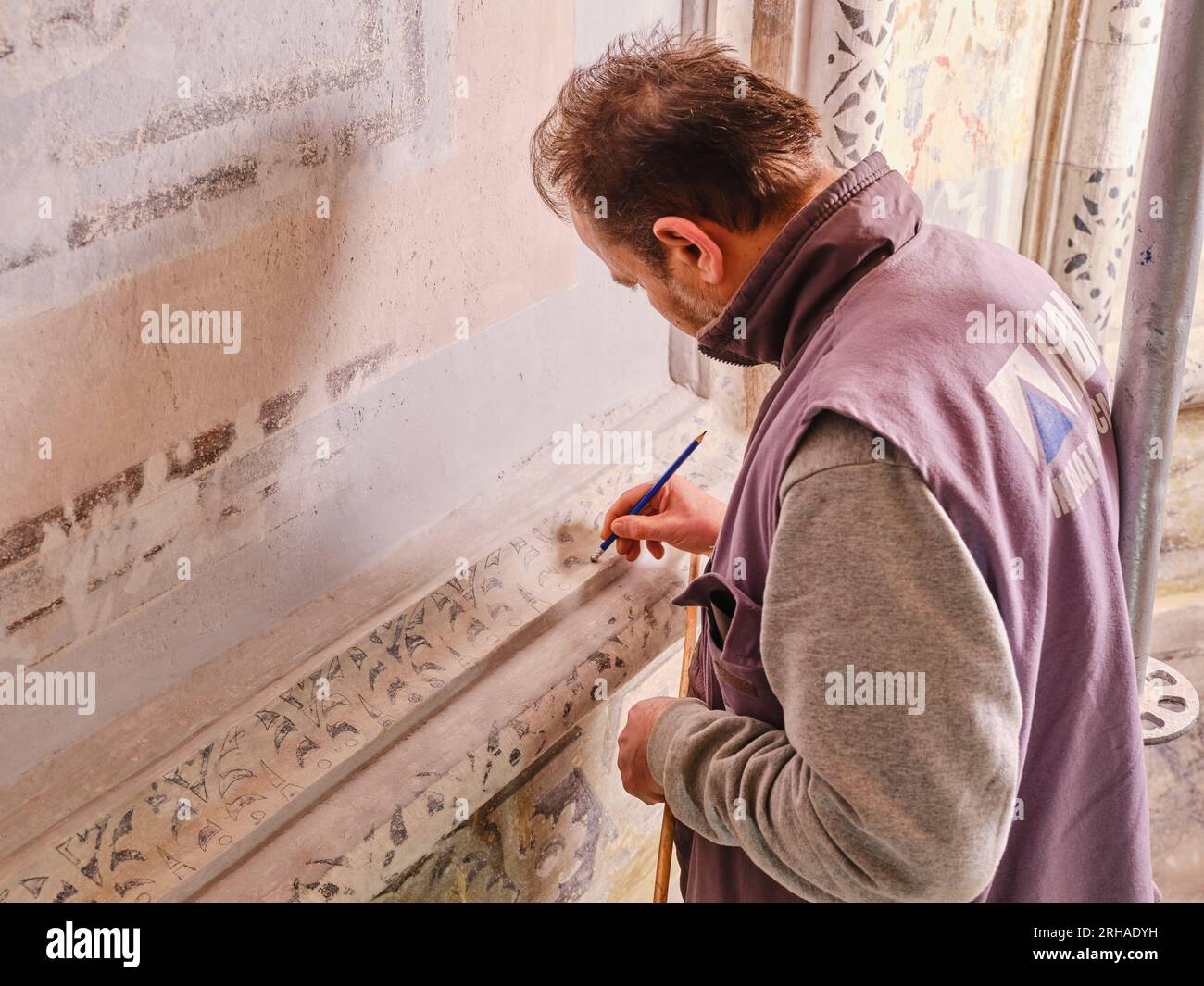 female artist doing old painting restoration. wall painting historical ...