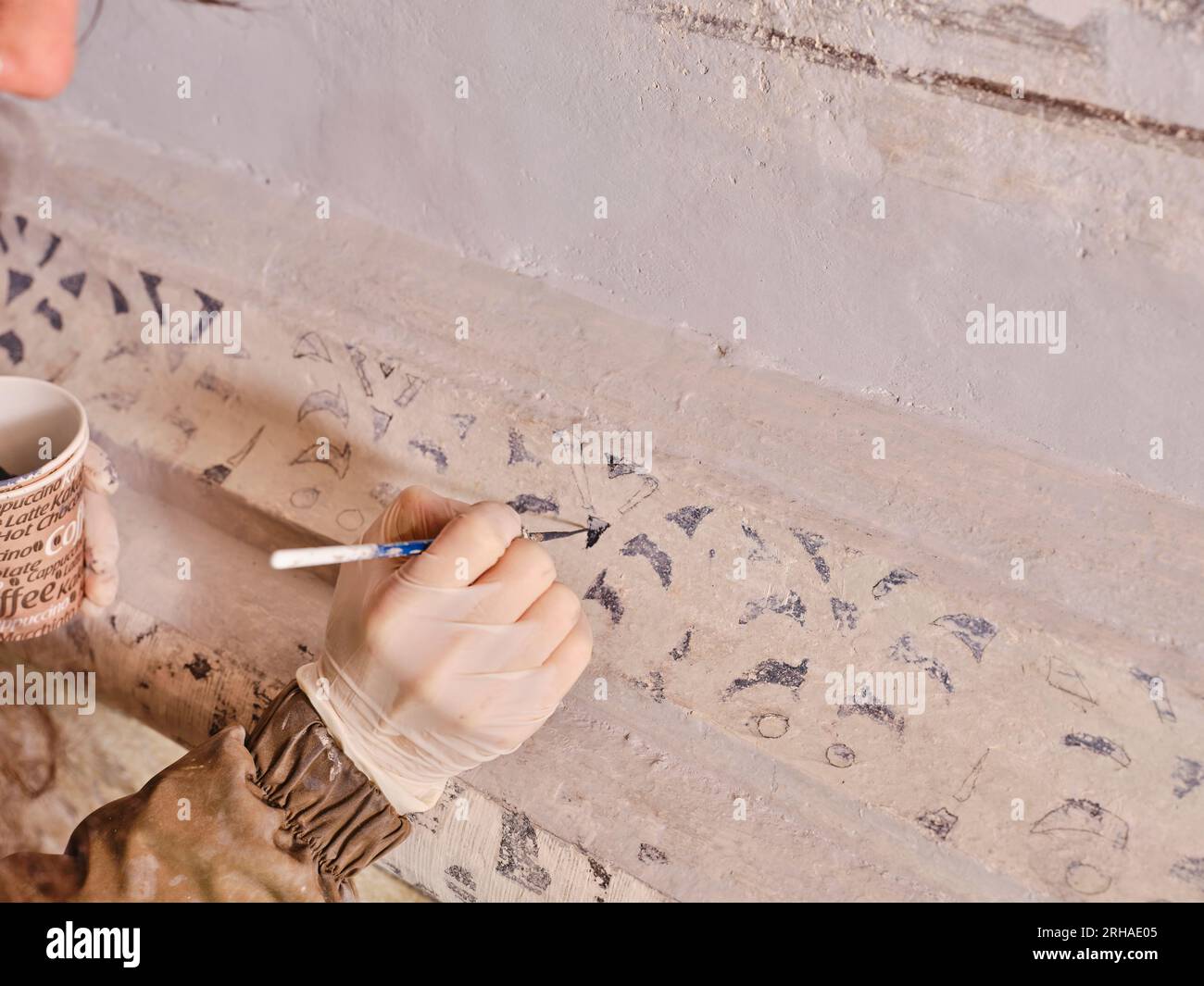 female artist doing old painting restoration. wall painting historical ...