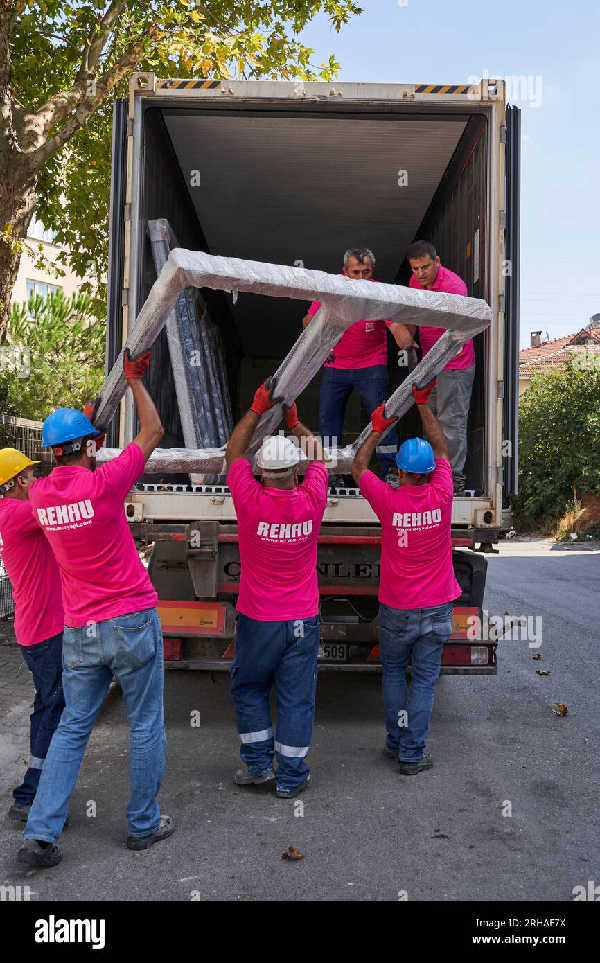 Workers packaging glass sheets in warehouse. worker shipping glass ...