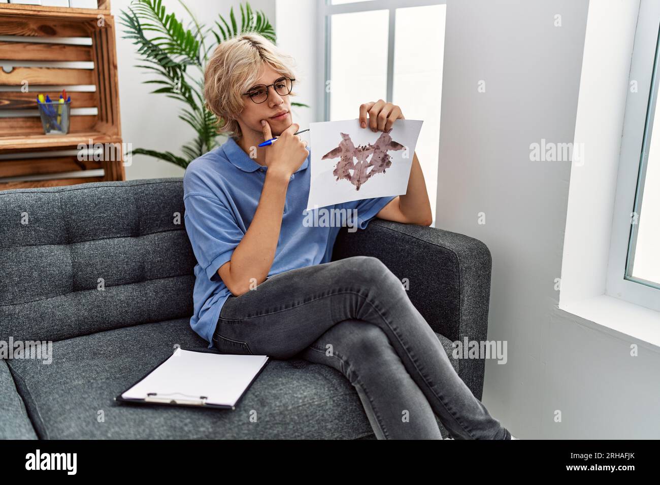 Young blond man psychologist having rorschach test at psychology clinic ...