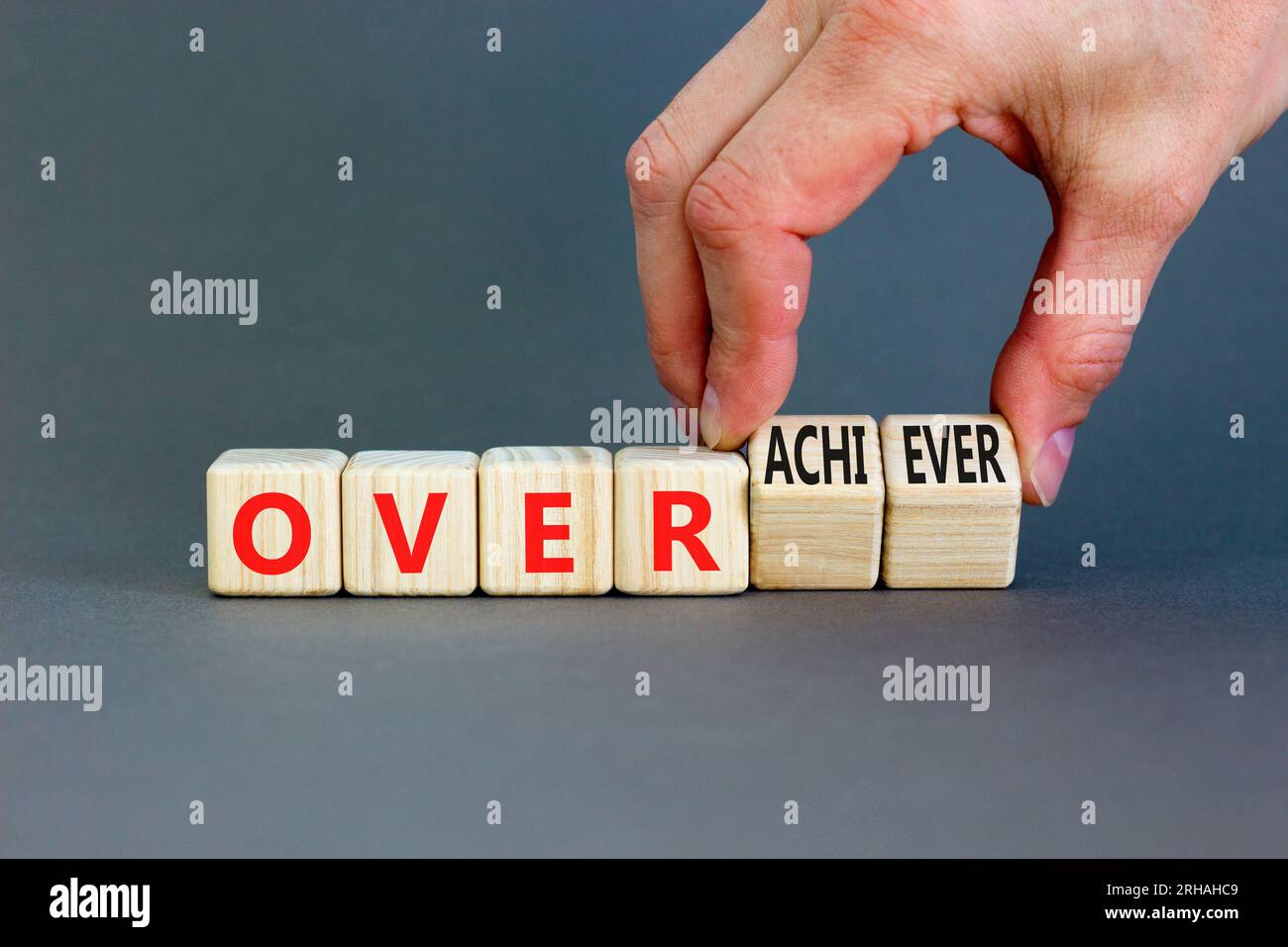 Achiever or overachiever symbol. Businessman turns wooden cubes and ...