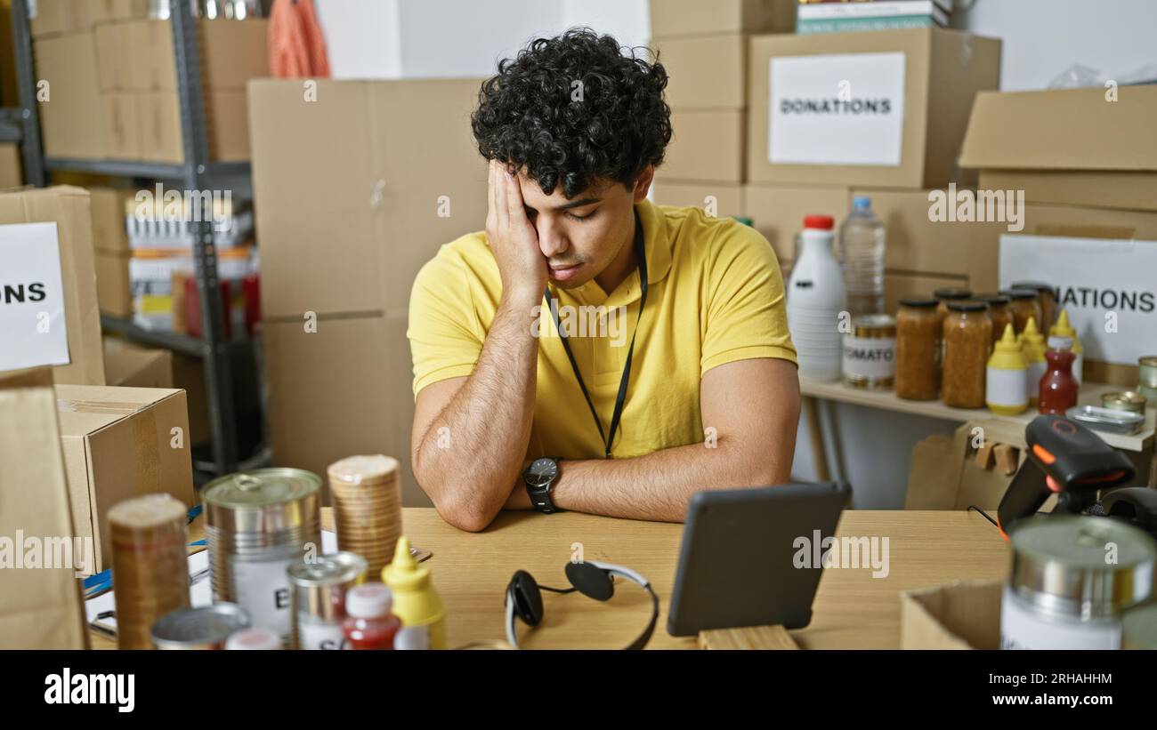 Young latin man volunteer stressed at charity center Stock Photo - Alamy
