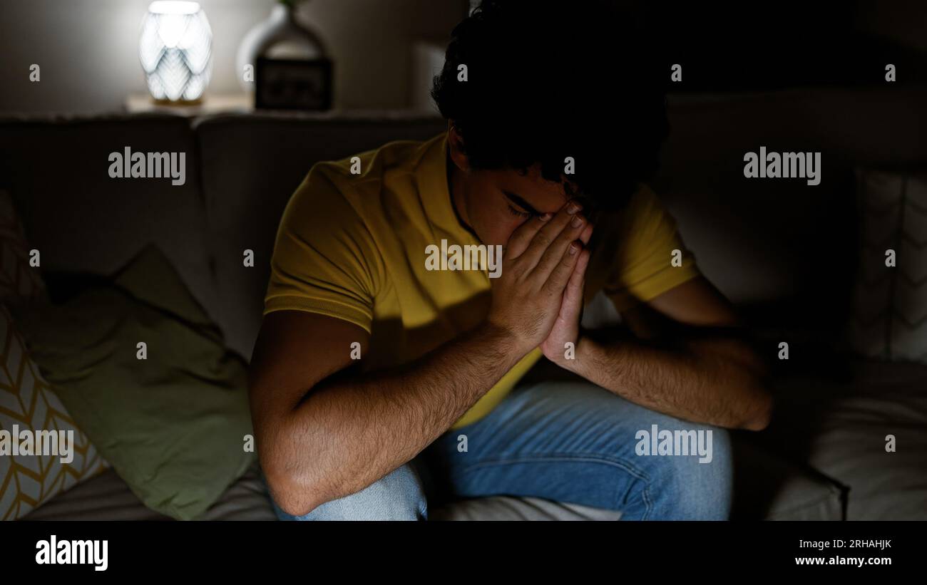 Young latin man stressed sitting on sofa crying at home Stock Photo - Alamy