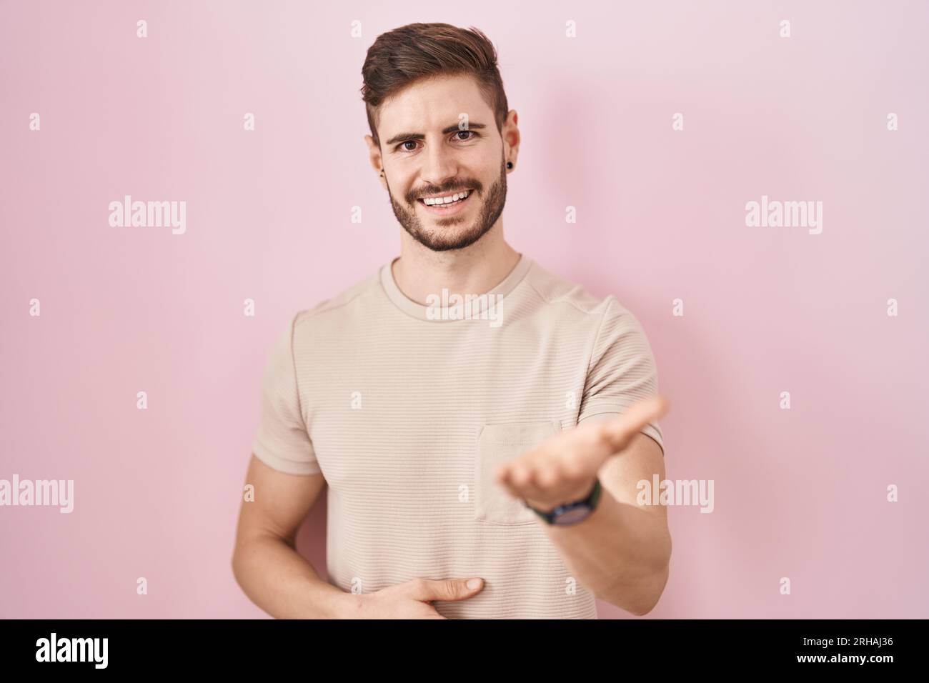 Hispanic man with beard standing over pink background smiling cheerful ...