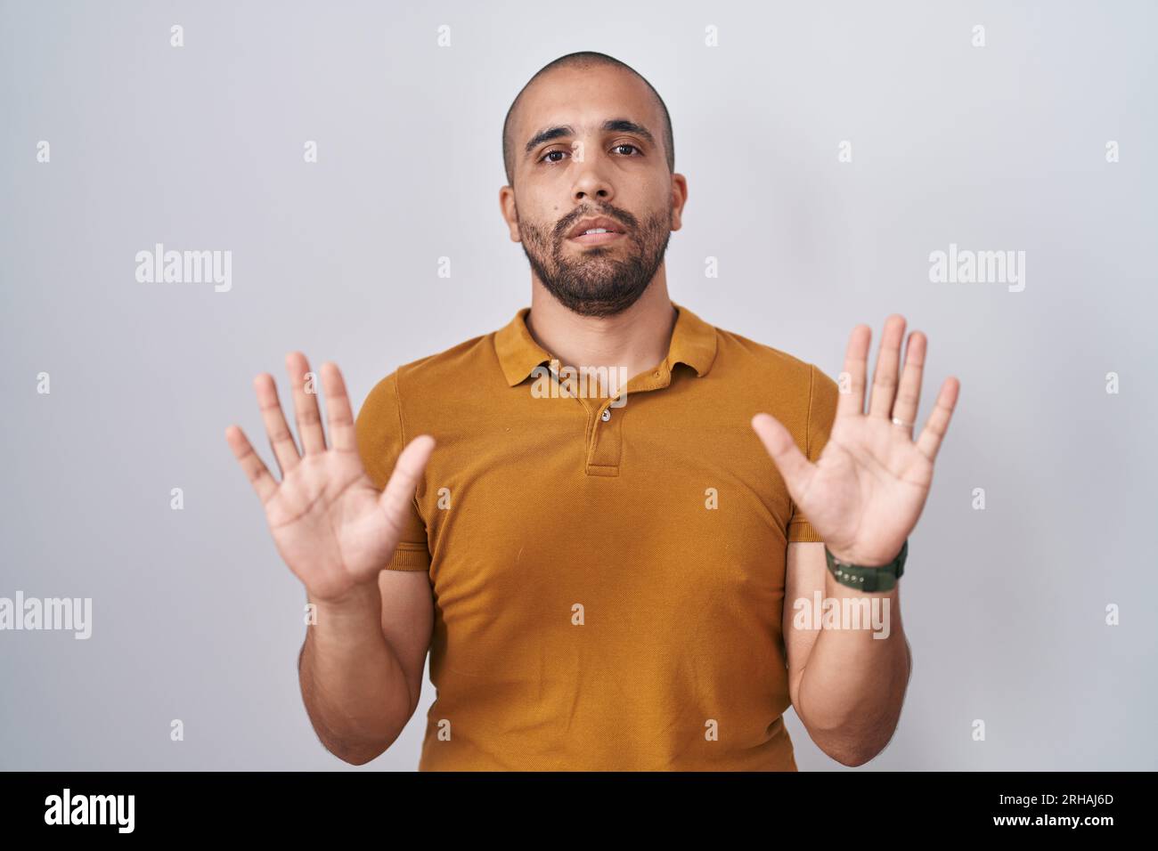 Hispanic man with beard standing over white background moving away ...