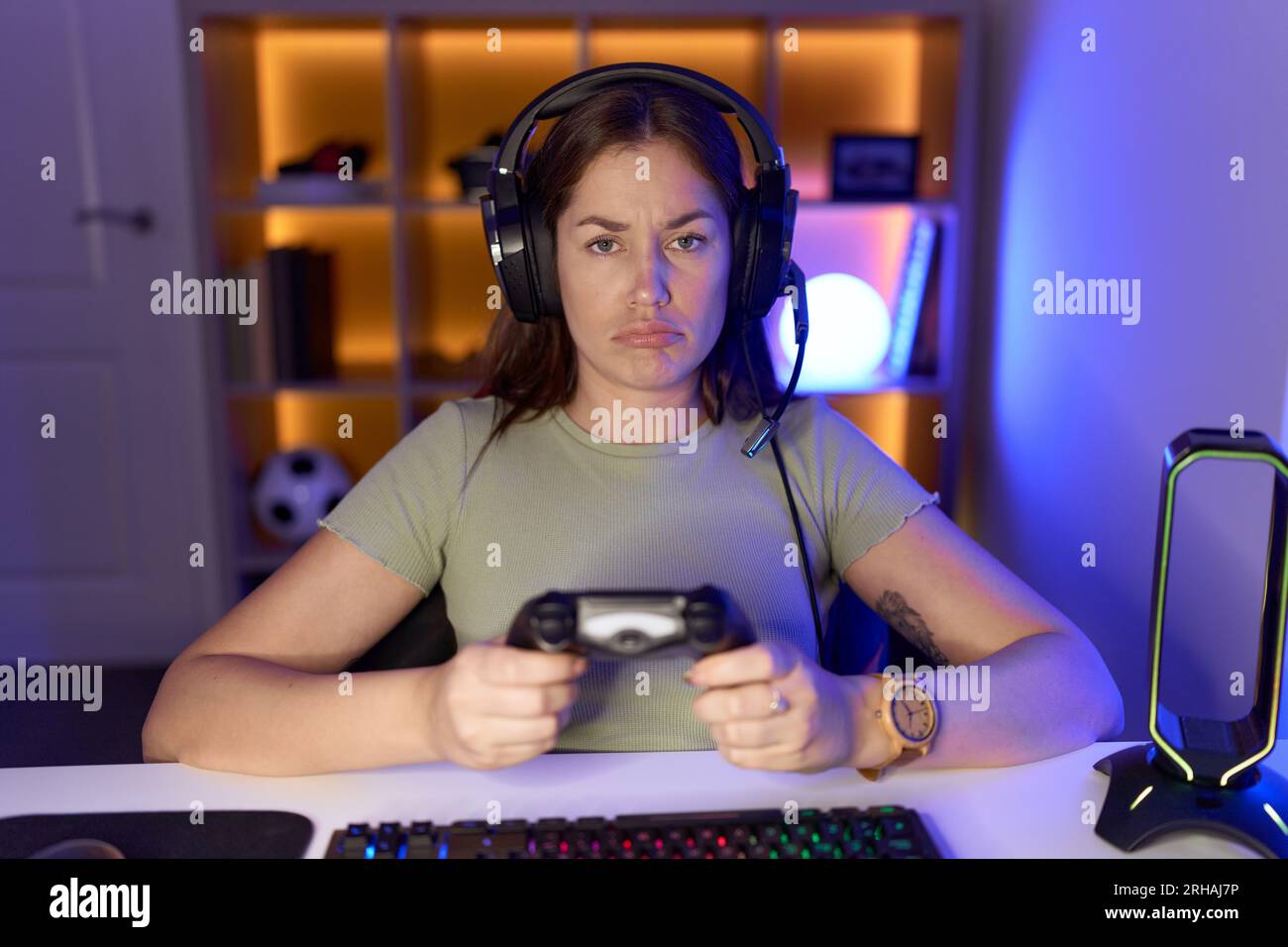 Beautiful brunette woman playing video games wearing headphones ...