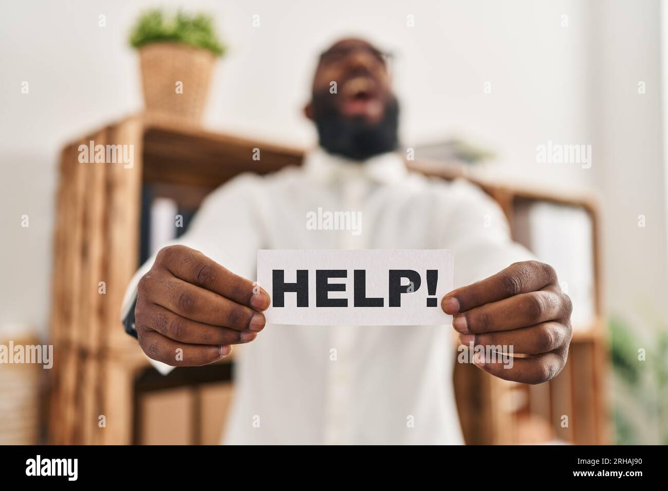 African american man holding help reminder angry and mad screaming ...