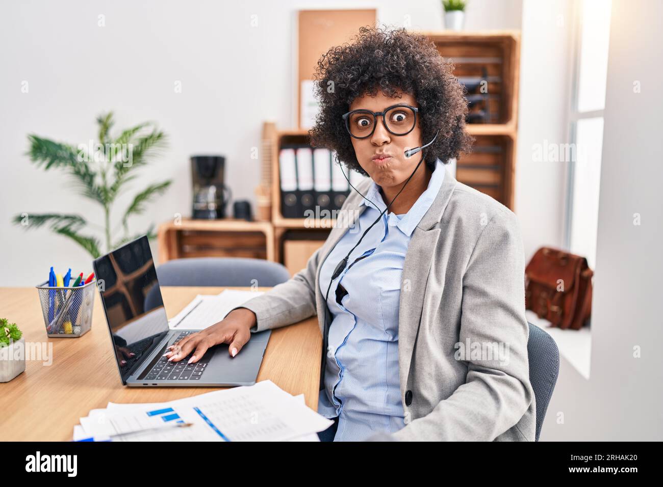 Black woman with curly hair wearing call center agent headset at the ...