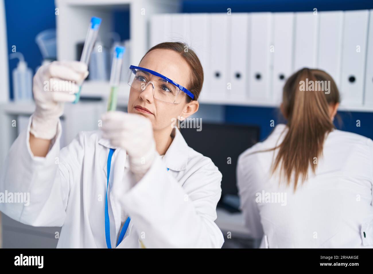 Two women scientists holding test tubes at laboratory Stock Photo - Alamy
