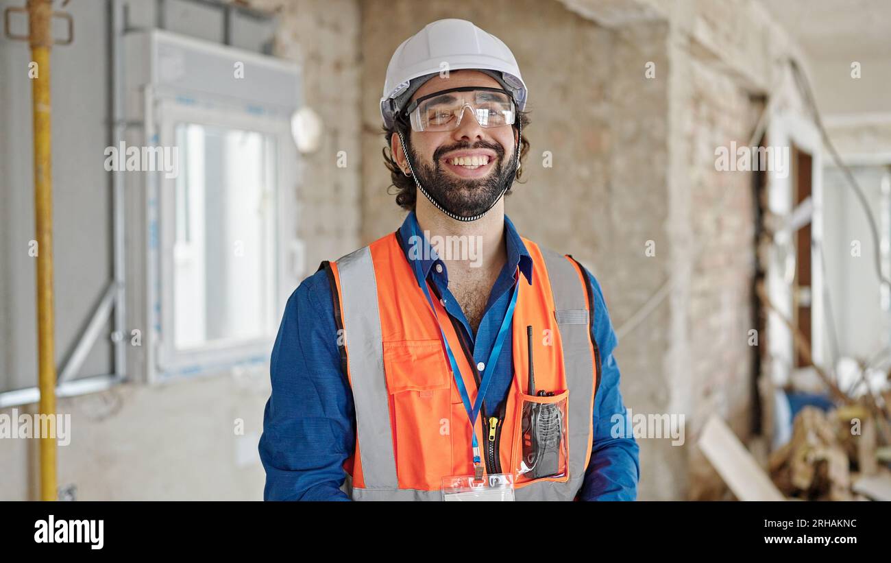 Young hispanic man architect smiling confident standing at construction ...
