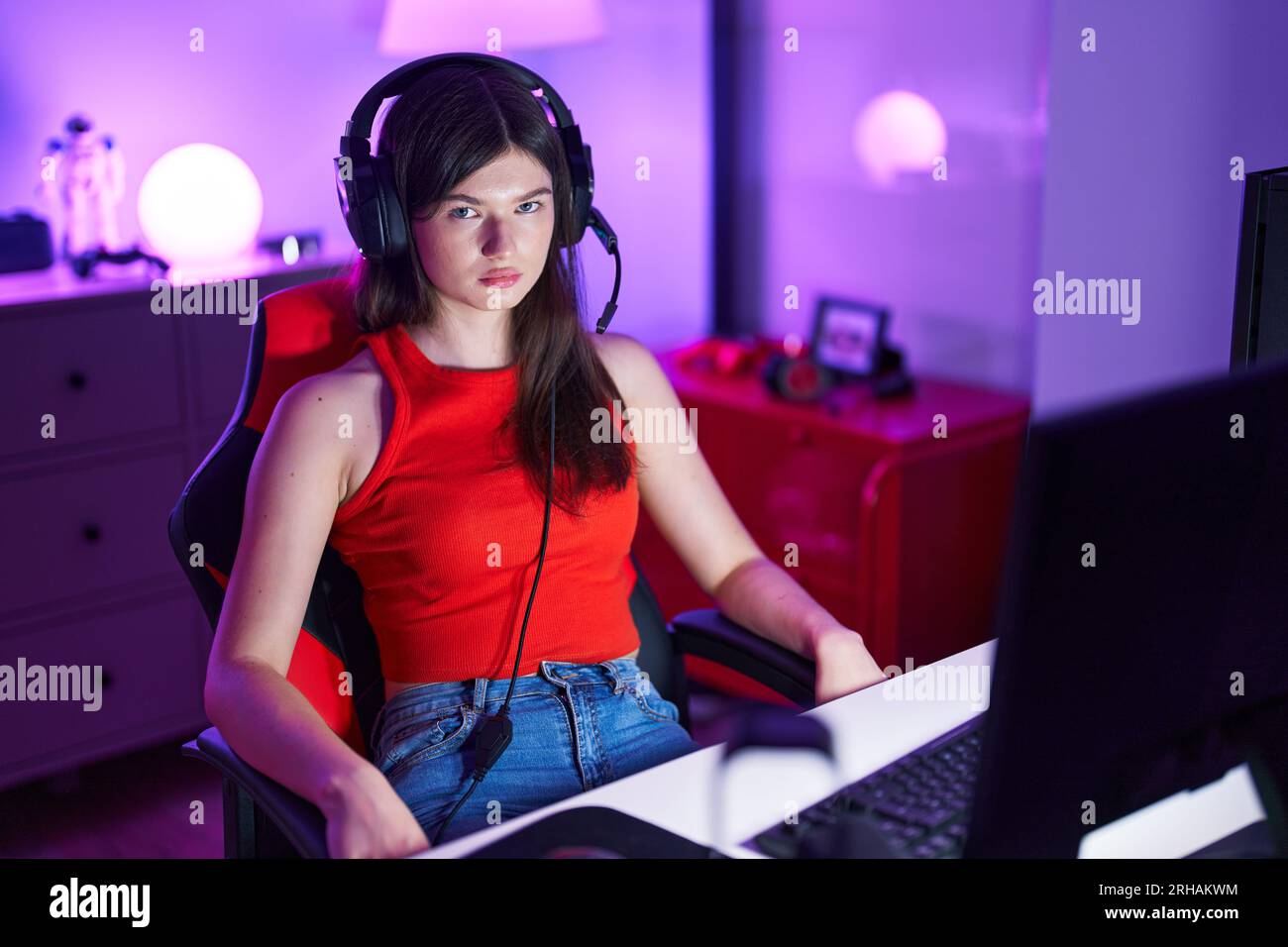 Young caucasian woman streamer sitting on table with serious expression ...