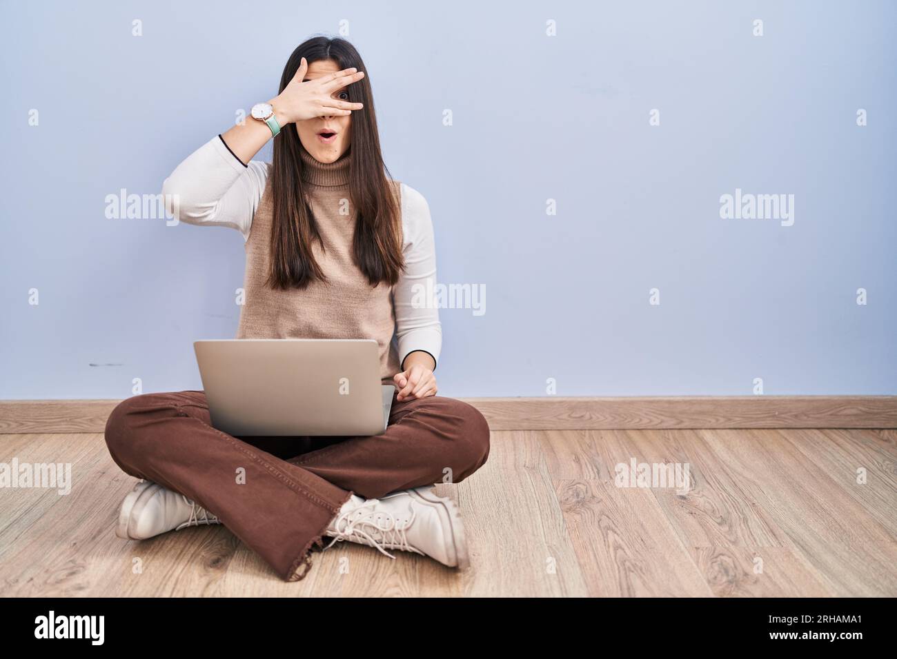 Young brunette woman working using computer laptop sitting on the floor ...