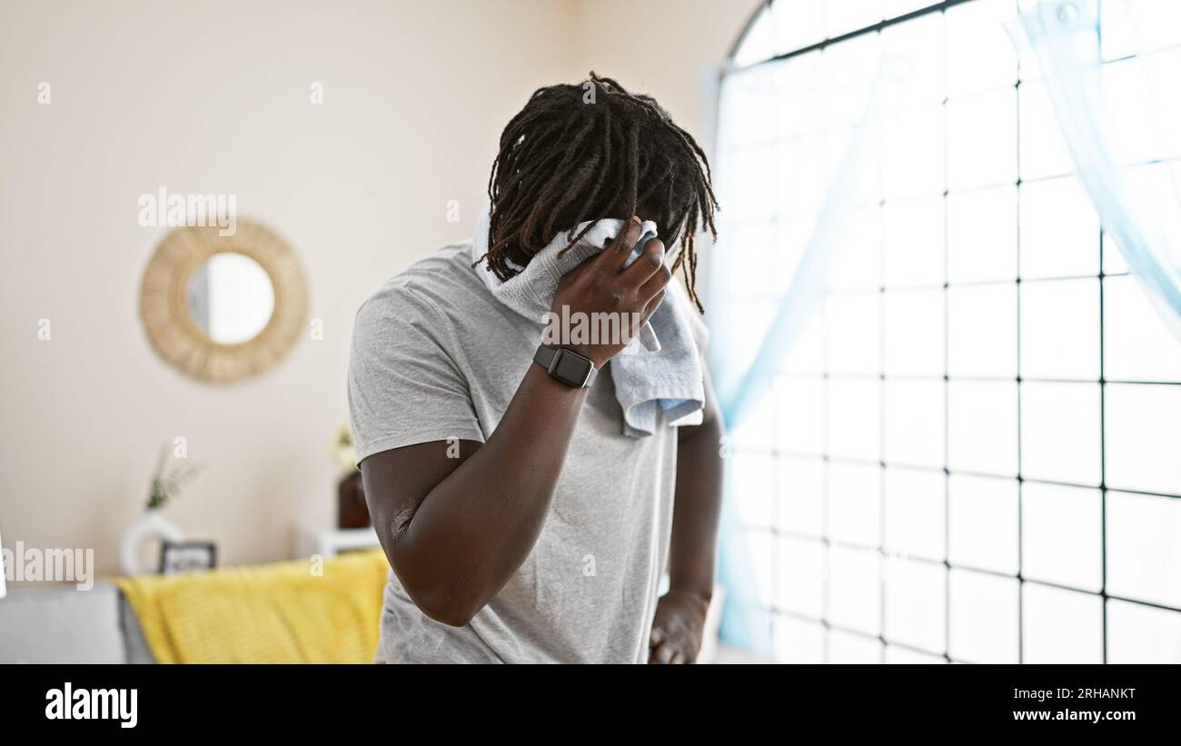 African american man standing with serious face sweating at home Stock ...