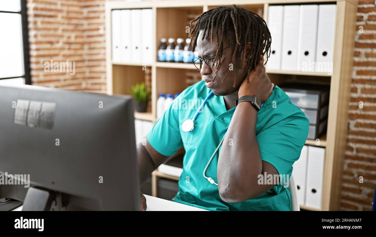 African american man doctor using computer suffering for cervical pain ...